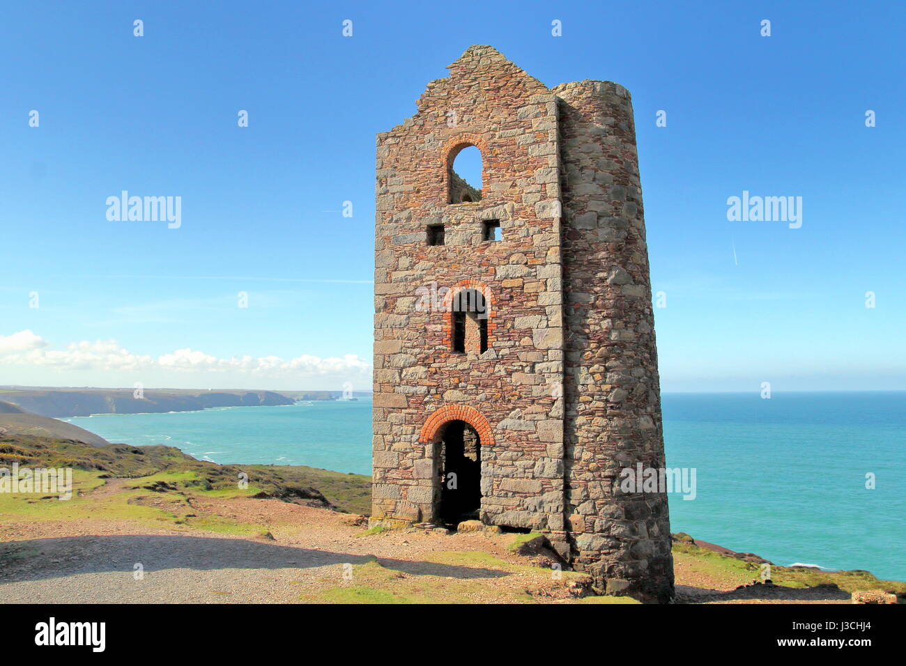Derelict abandoned Cornish tin mine building on coast path with sea and ...