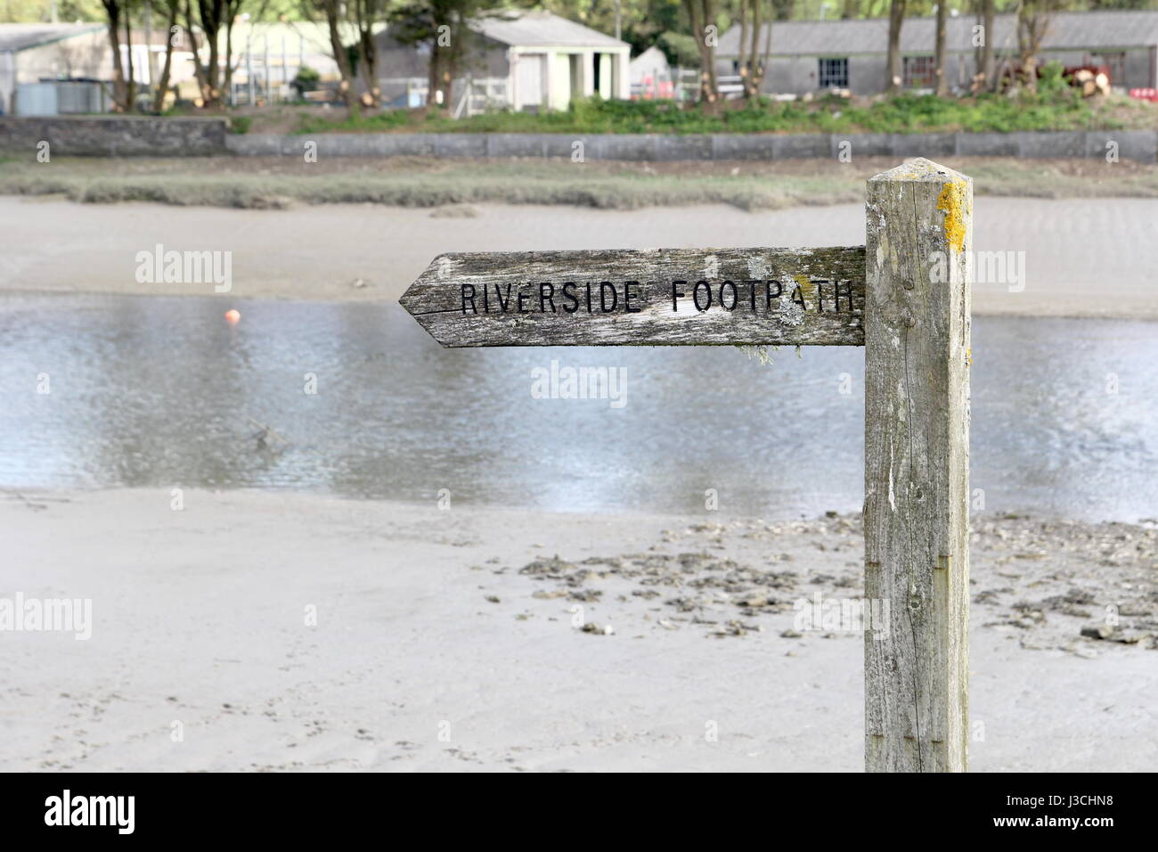 Wooden sign with river in distance, reading "Riverside Footpath Stock ...