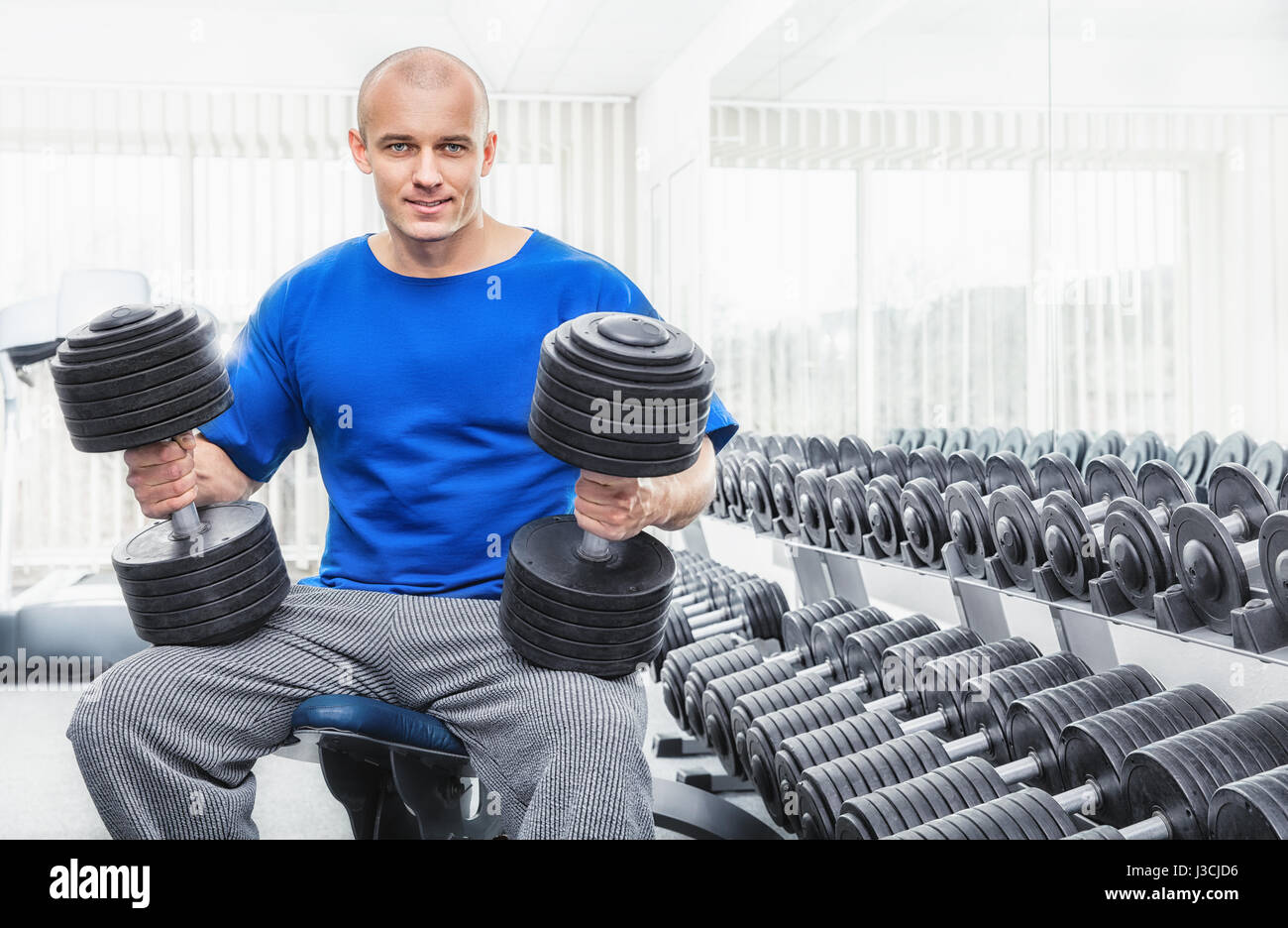 Portrait of strong man in the gym with weight lifting Stock Photo - Alamy
