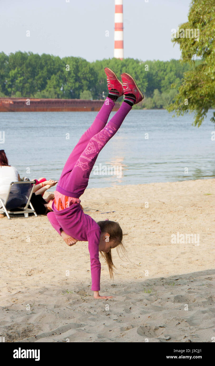 Girl doing a handstand and backflip in front Stock Photo - Alamy