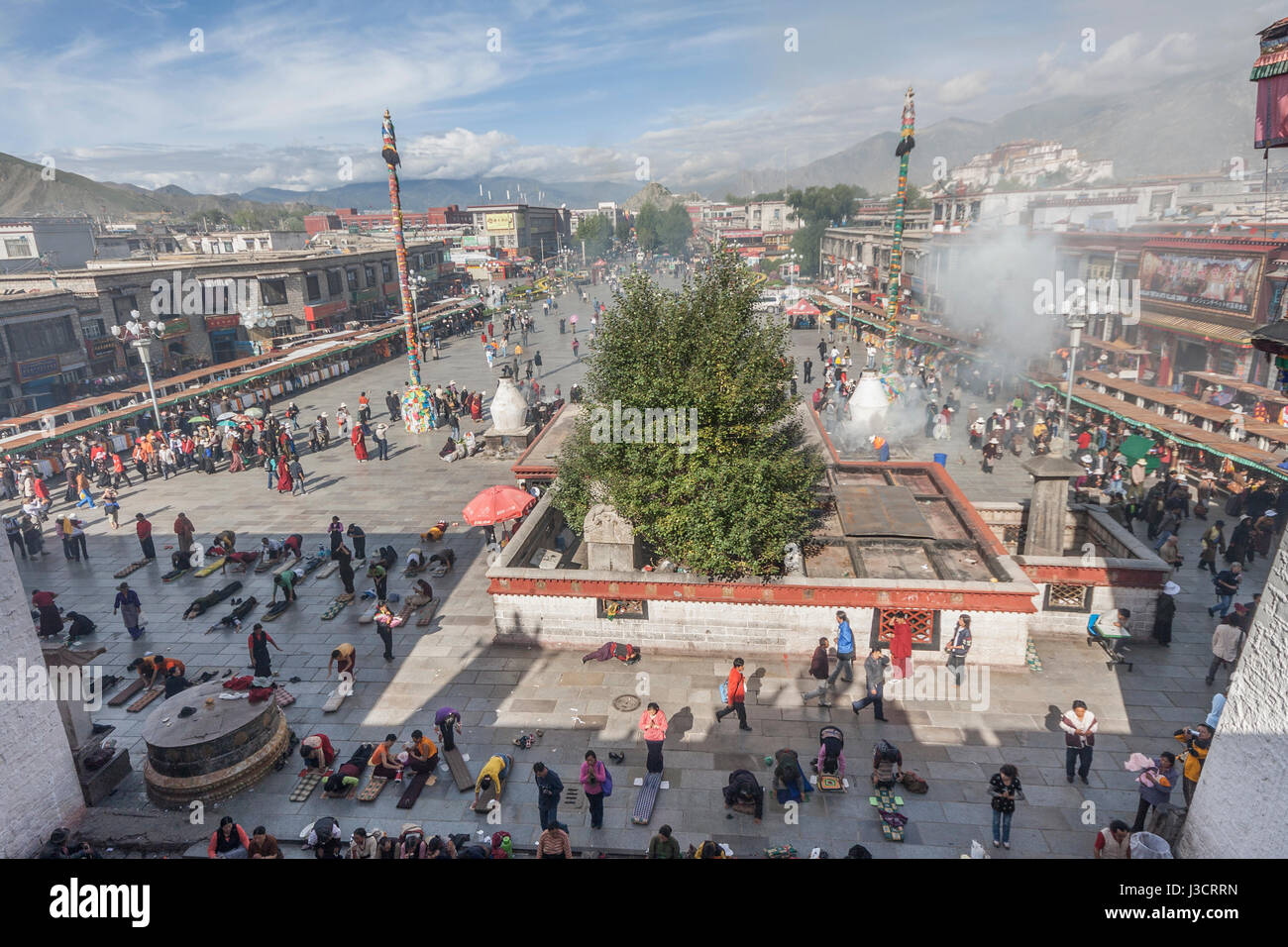 Morning view of crowded Barkhor square filled with juniper smoke, Lhasa ...