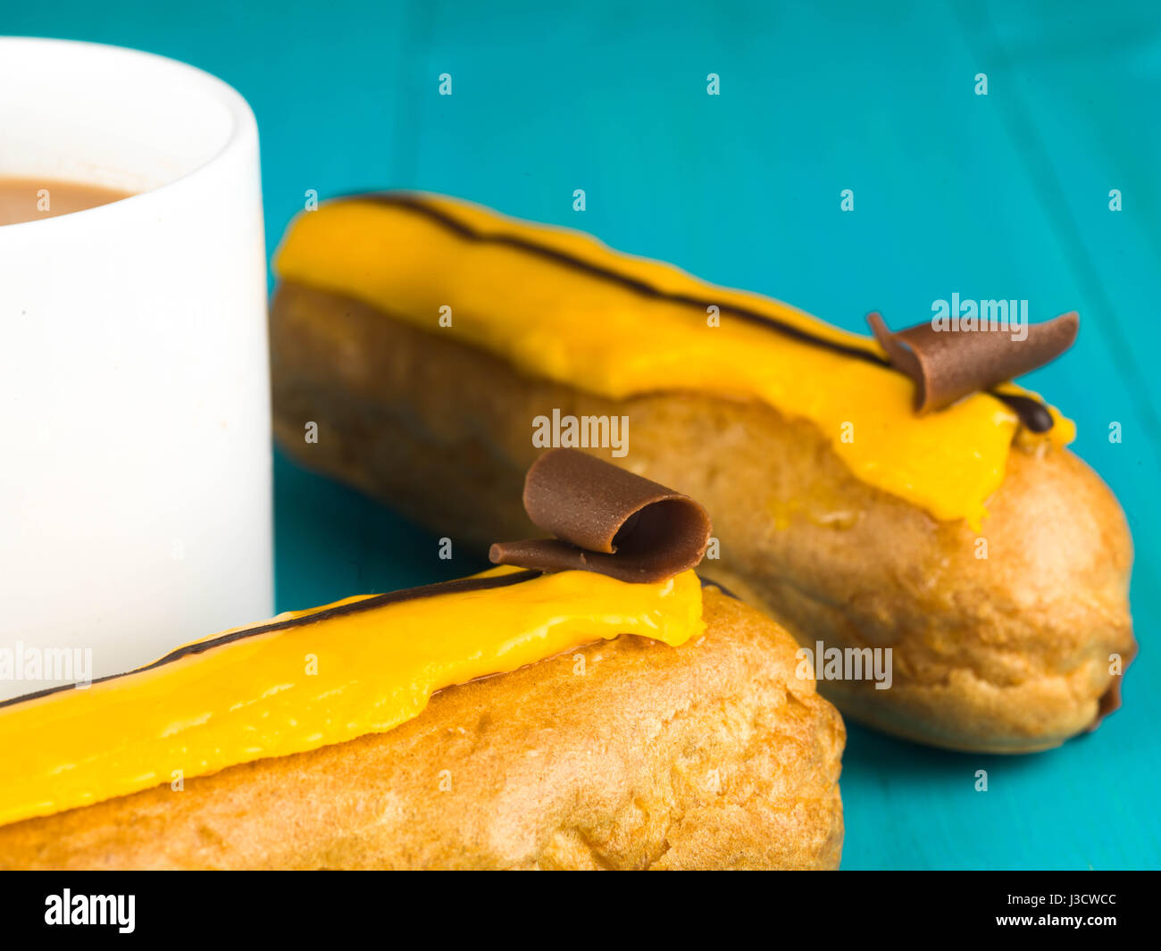Two Choux Pastry Orange Eclairs Against a Blue Background Stock Photo ...