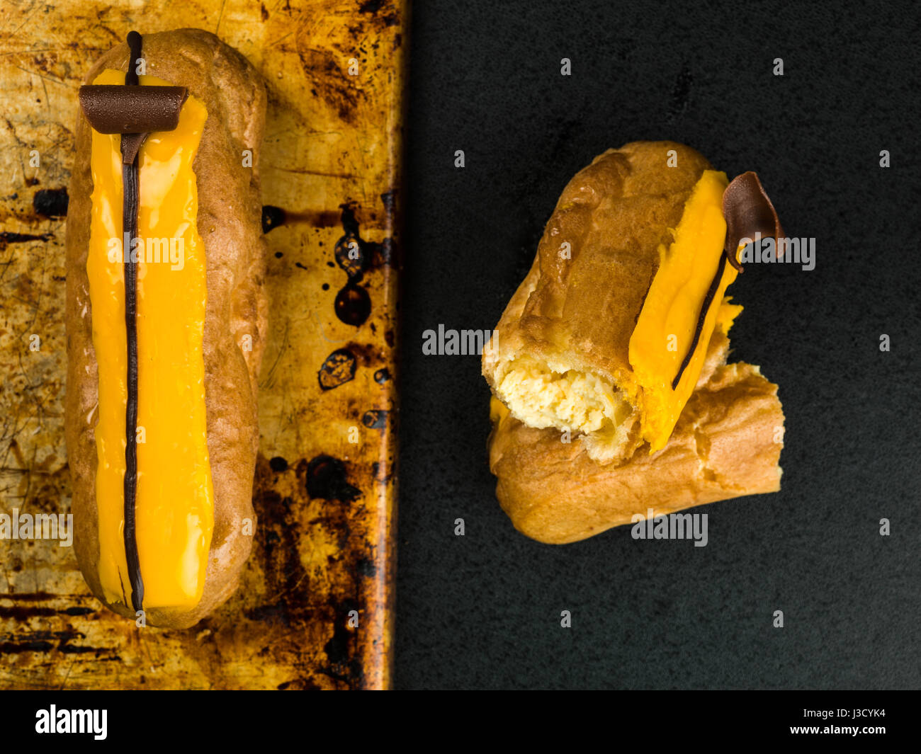 Two Choux Pastry Orange Eclairs Against a Black Background Stock Photo ...