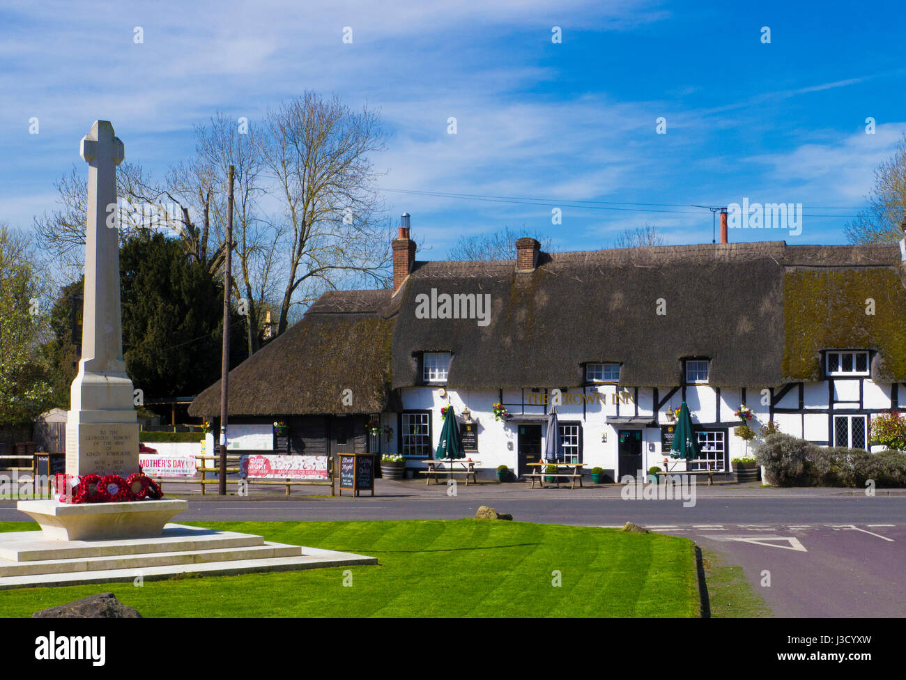 The Crown Inn ,a typical thatched roof pub and War Memorial in the ...