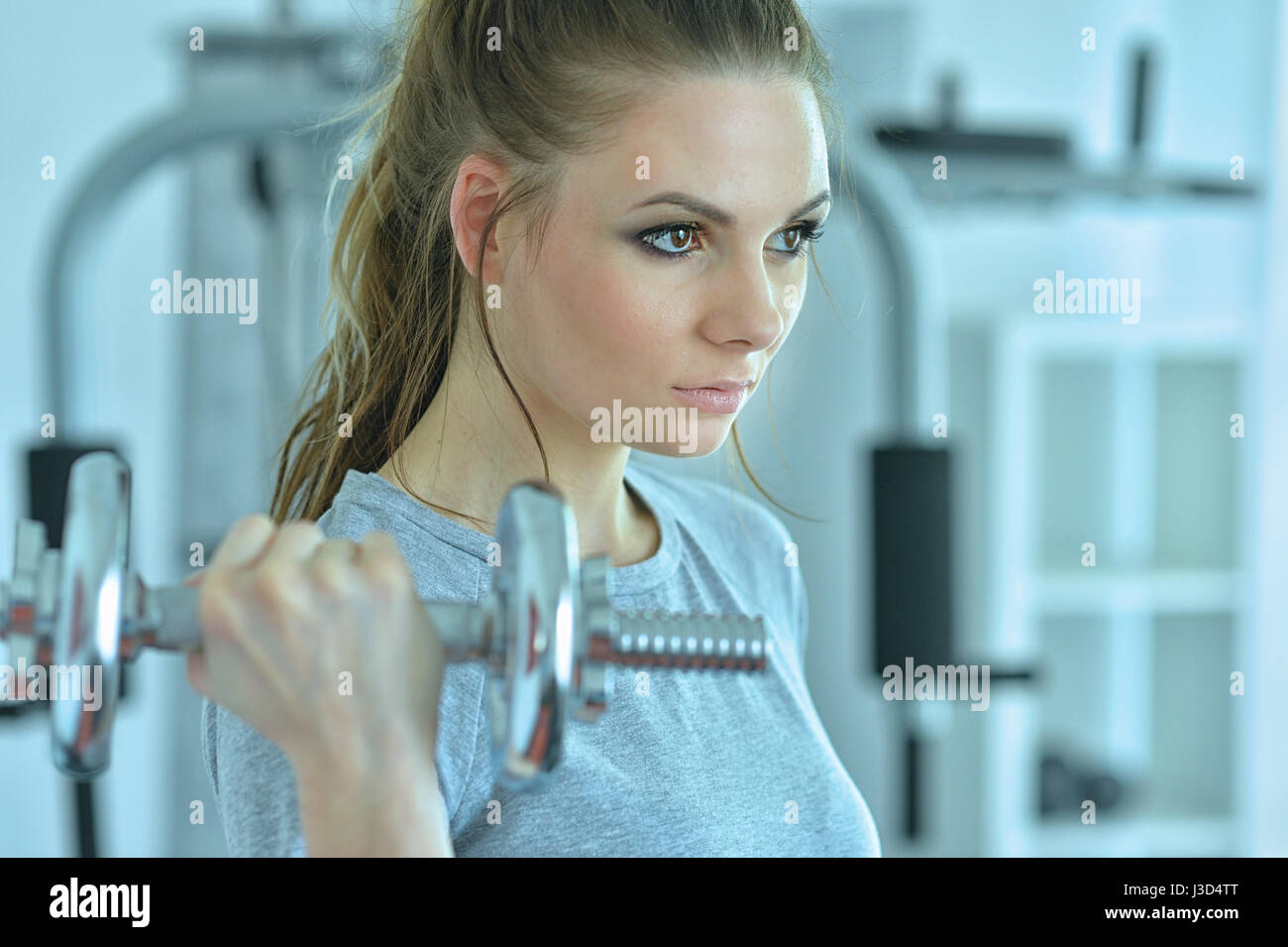 Young woman in a gym with a dumbbell Stock Photo - Alamy