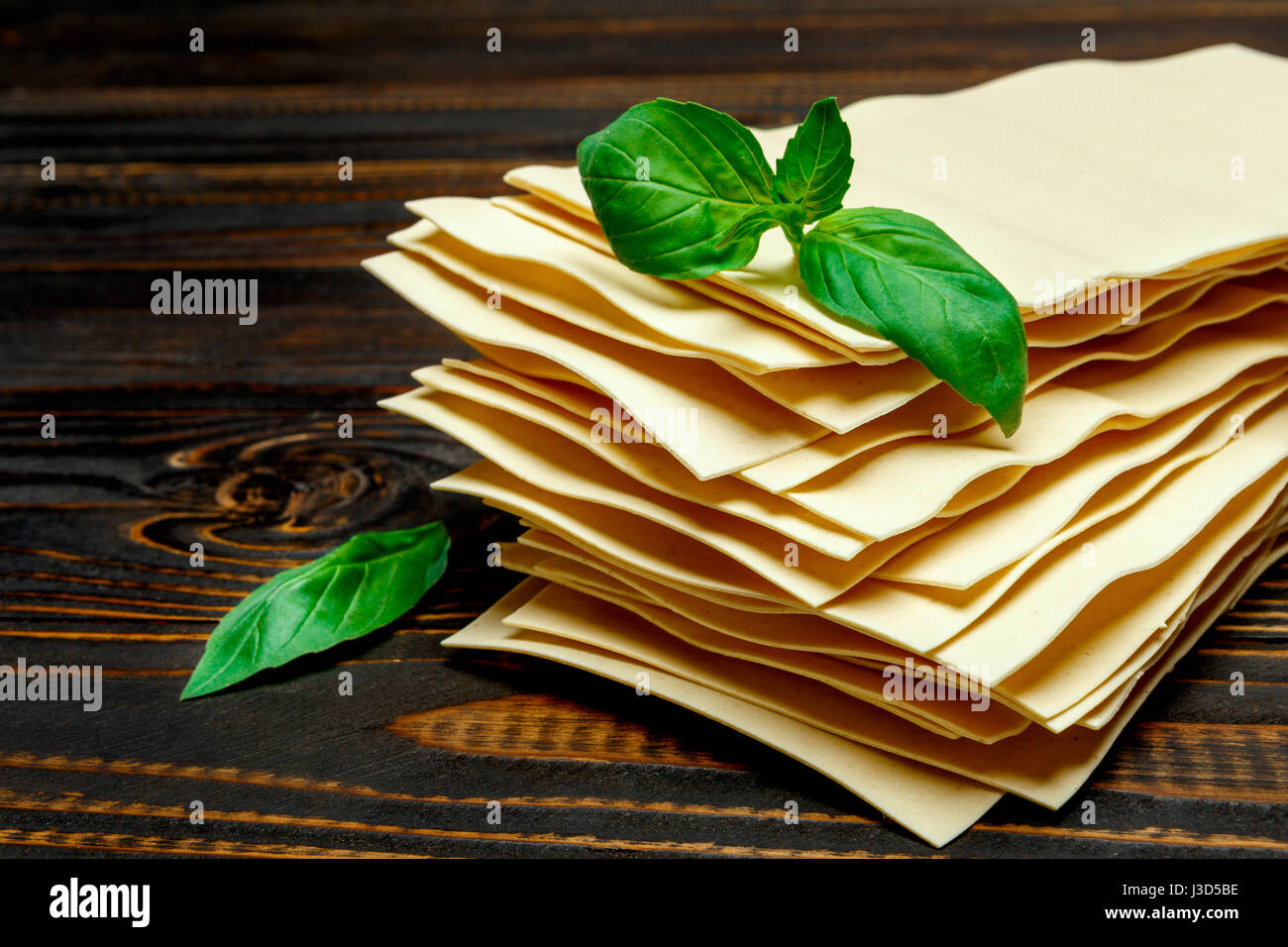 dried uncooked lasagna pasta sheets on wooden background Stock Photo ...
