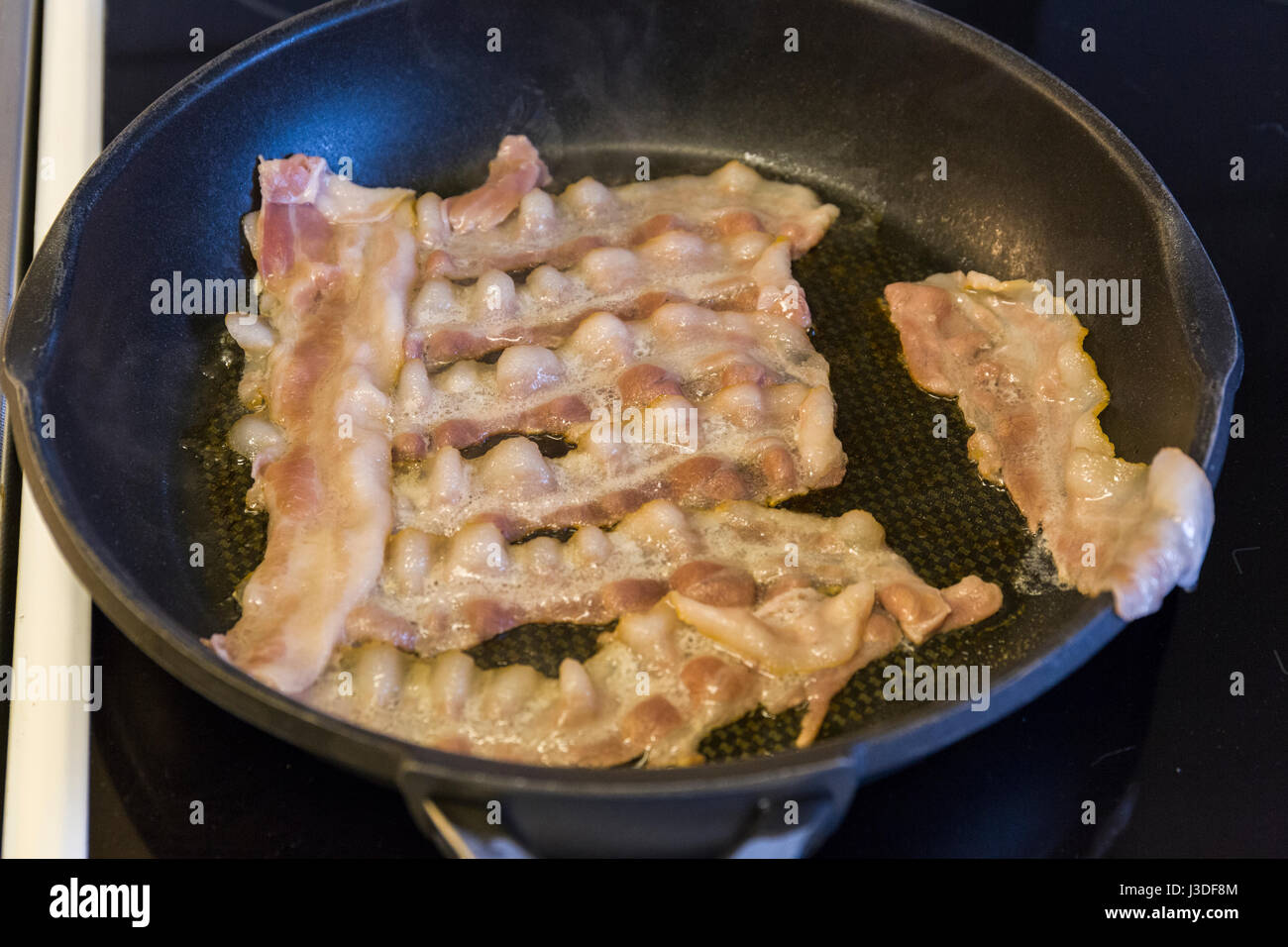 Strips of bacon sizzling in frying pan Model Release: No. Property ...