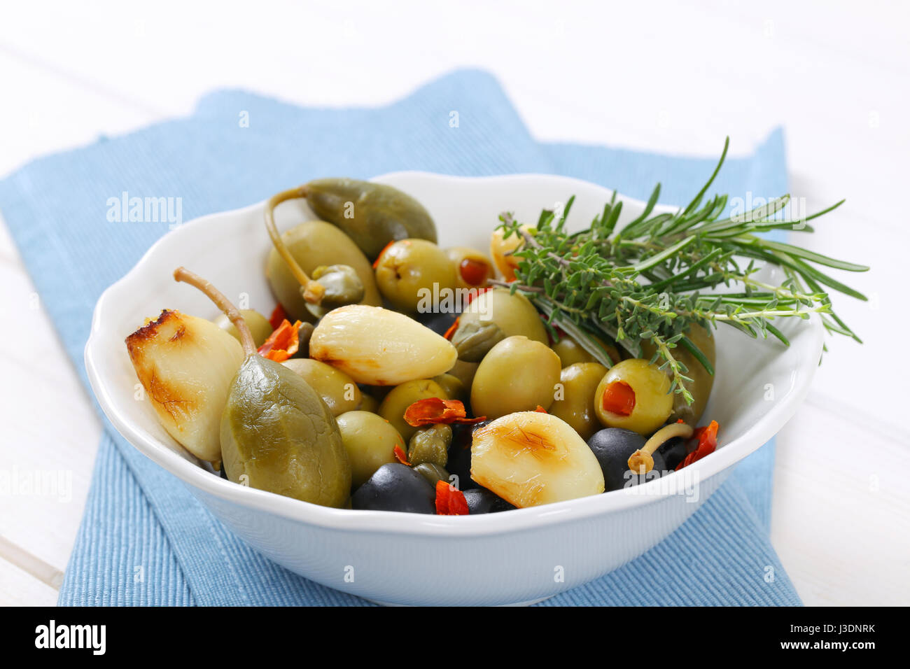 bowl of pickled olives, capers, caper berries and garlic Stock Photo ...