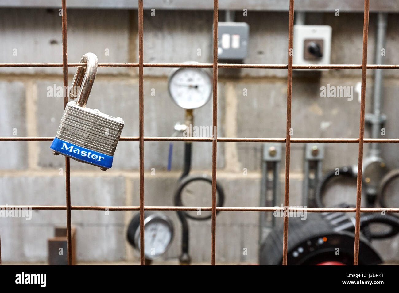 An unlocked padlock hung on a wire mesh in a plant room Stock Photo - Alamy
