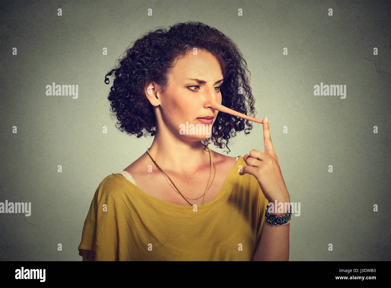 Woman with long nose isolated on grey wall background. Liar concept ...