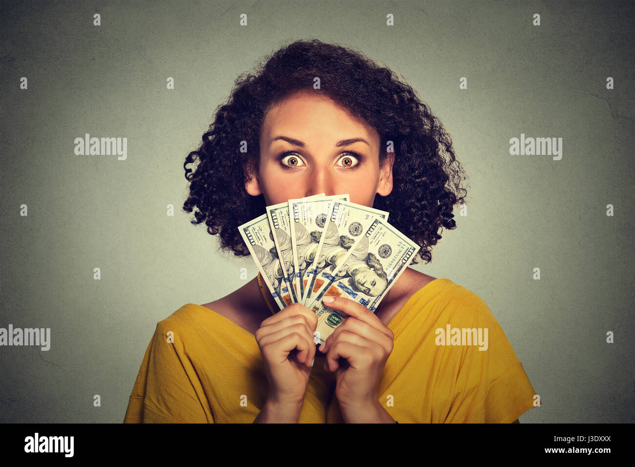Scared looking woman hiding picking through dollar banknotes Stock ...