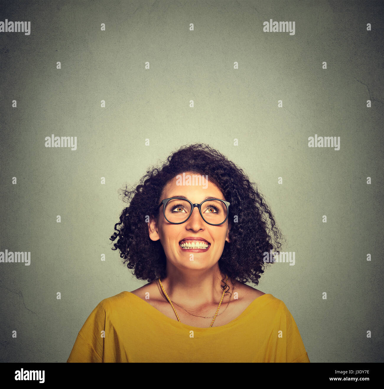 Portrait of a super excited happy funky girl in glasses looking up ...