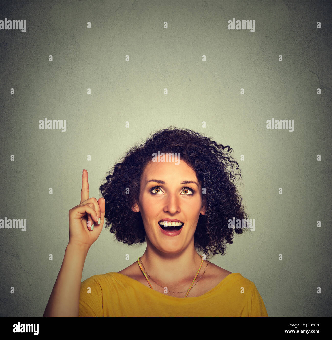 Portrait happy beautiful woman with idea looking up pointing with ...