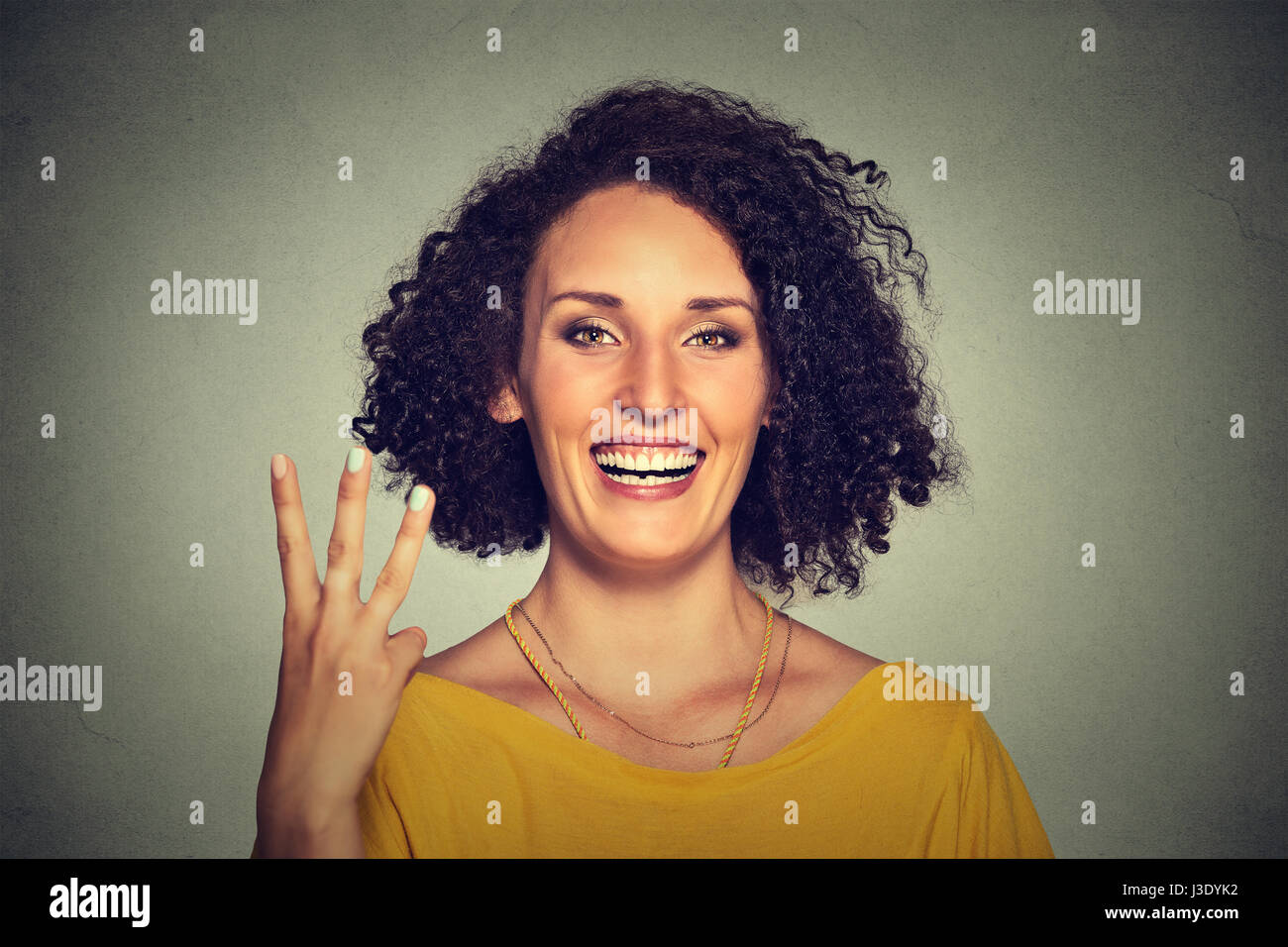 Closeup portrait of young pretty woman giving a three fingers sign ...