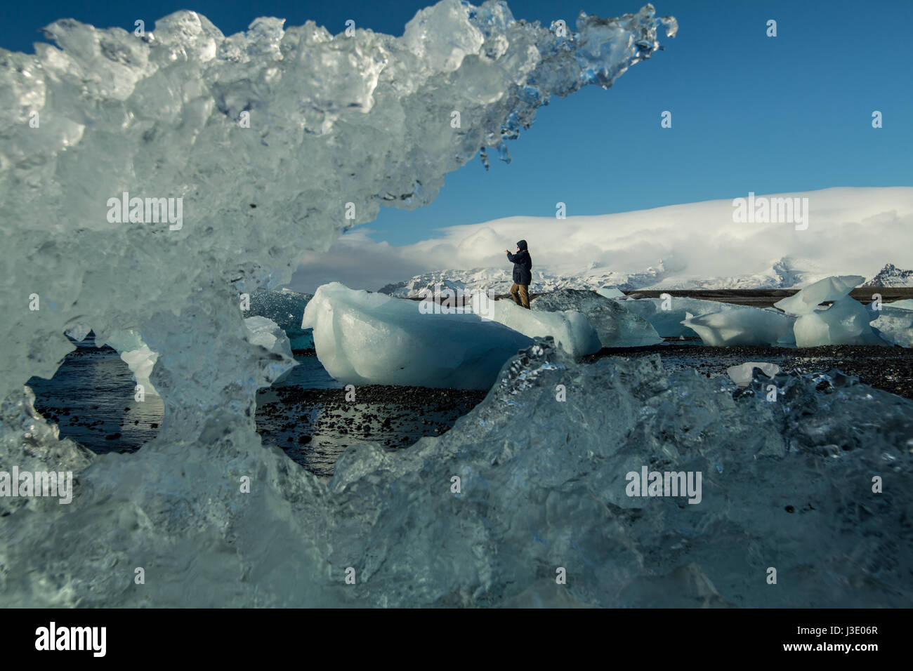 Figure standing on ice flow at the glacial beach in Iceland Stock Photo ...