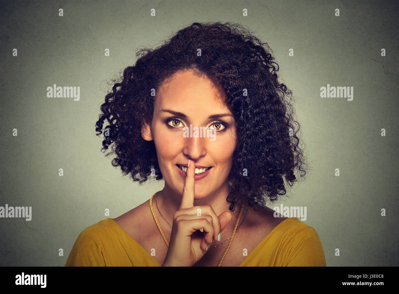 Closeup portrait happy young woman placing finger on lips asking shhhhh ...