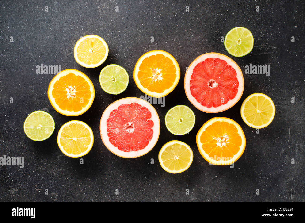 Mix of citrus fruits on dark table Stock Photo - Alamy