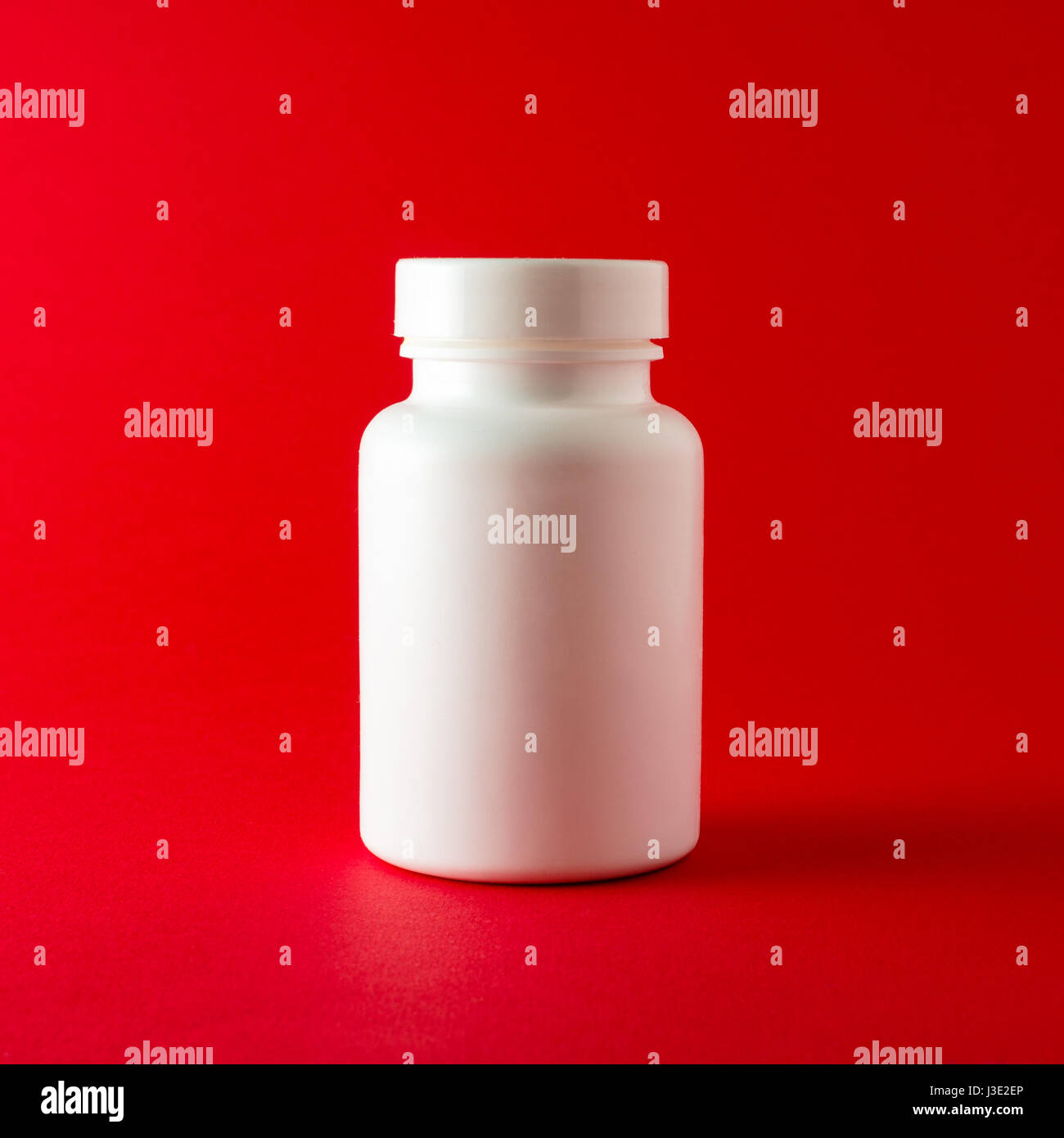 Pill bottle on red background Stock Photo - Alamy