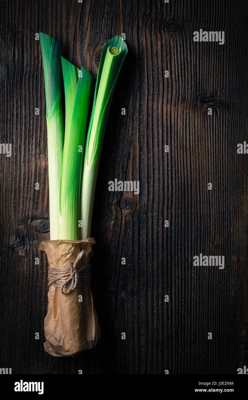 Fresh leeks on wooden table Stock Photo - Alamy