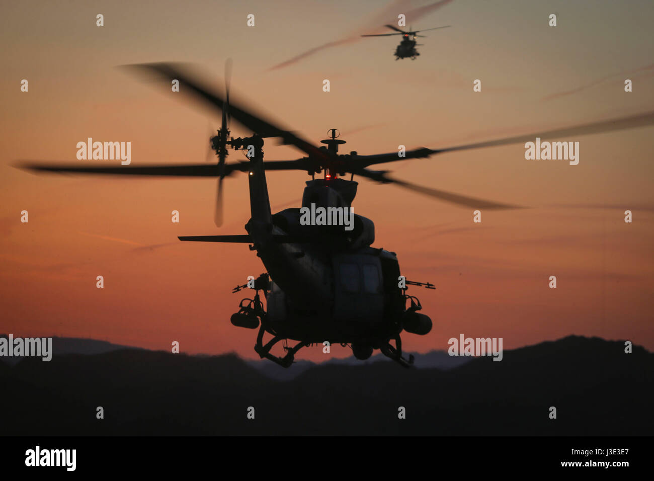 USMC UH-1Y Venom helicopters fly off in the sunset at the Yuma Proving ...