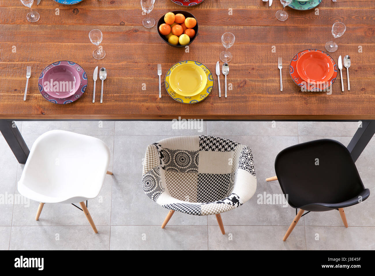 Dining wooden table and color porcelain plates Stock Photo - Alamy