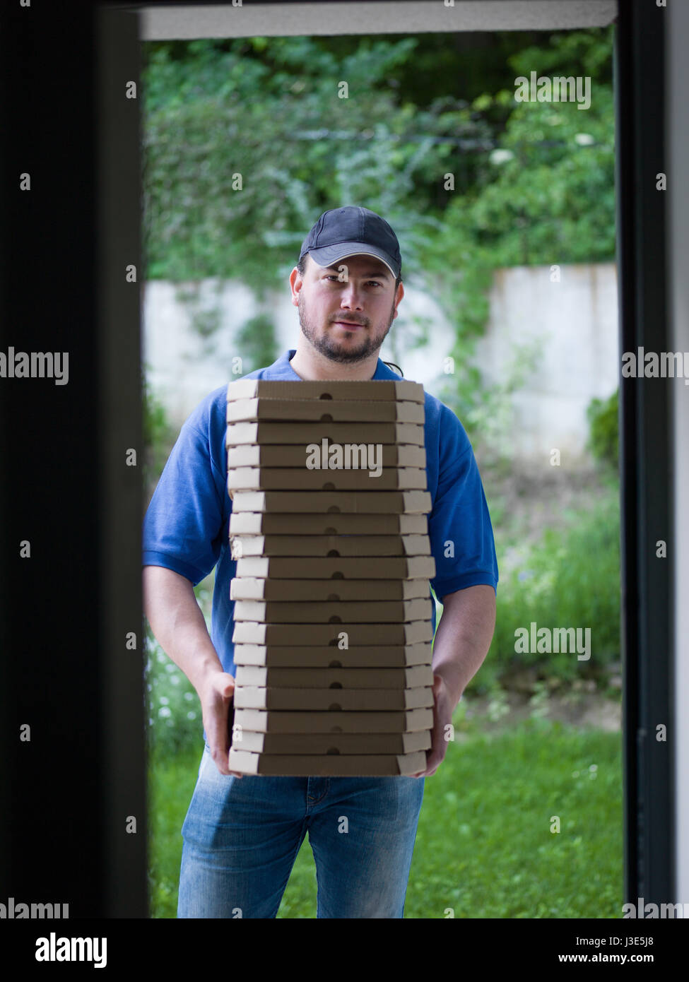 pizza delivery portrait of a young deliverers with lots of stacked ...