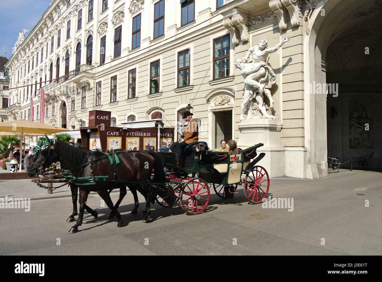 a traditional fiaker, horse-drawn carriage at the entrance of the ...
