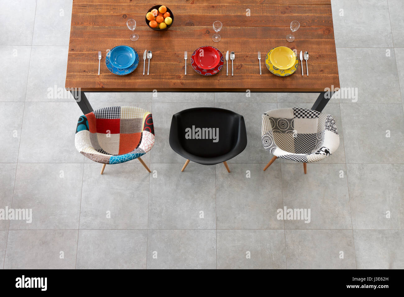 Dining wooden table and color porcelain plates Stock Photo - Alamy