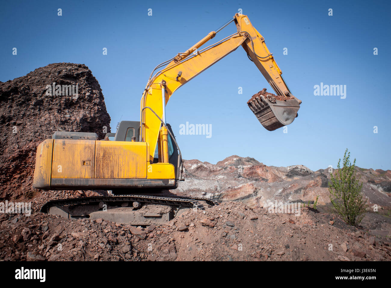 A large construction excavator of yellow color on the construction site ...