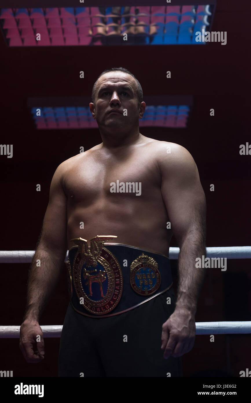 portrait of muscular professional kick boxer with his championship belt ...