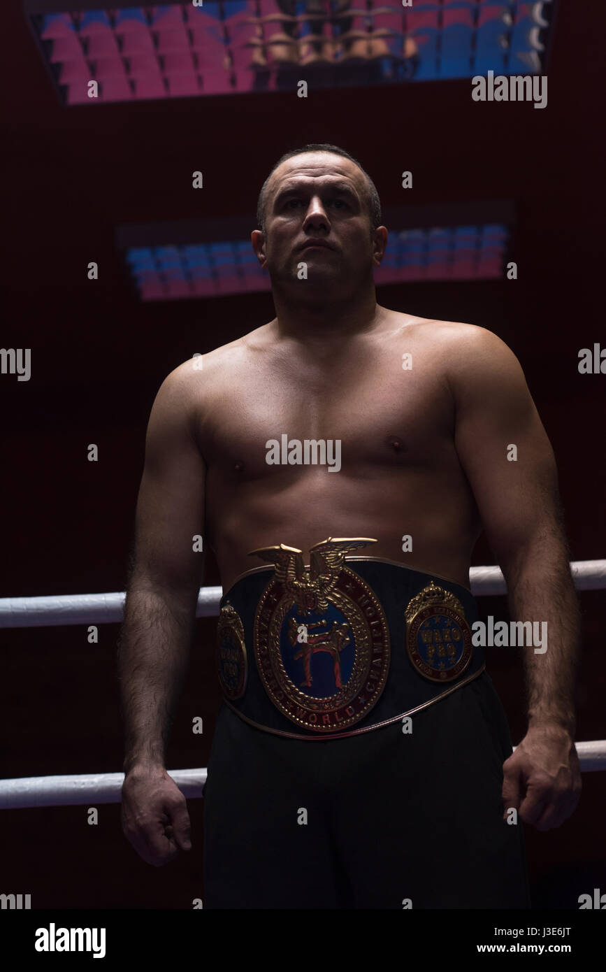 portrait of muscular professional kick boxer with his championship belt ...