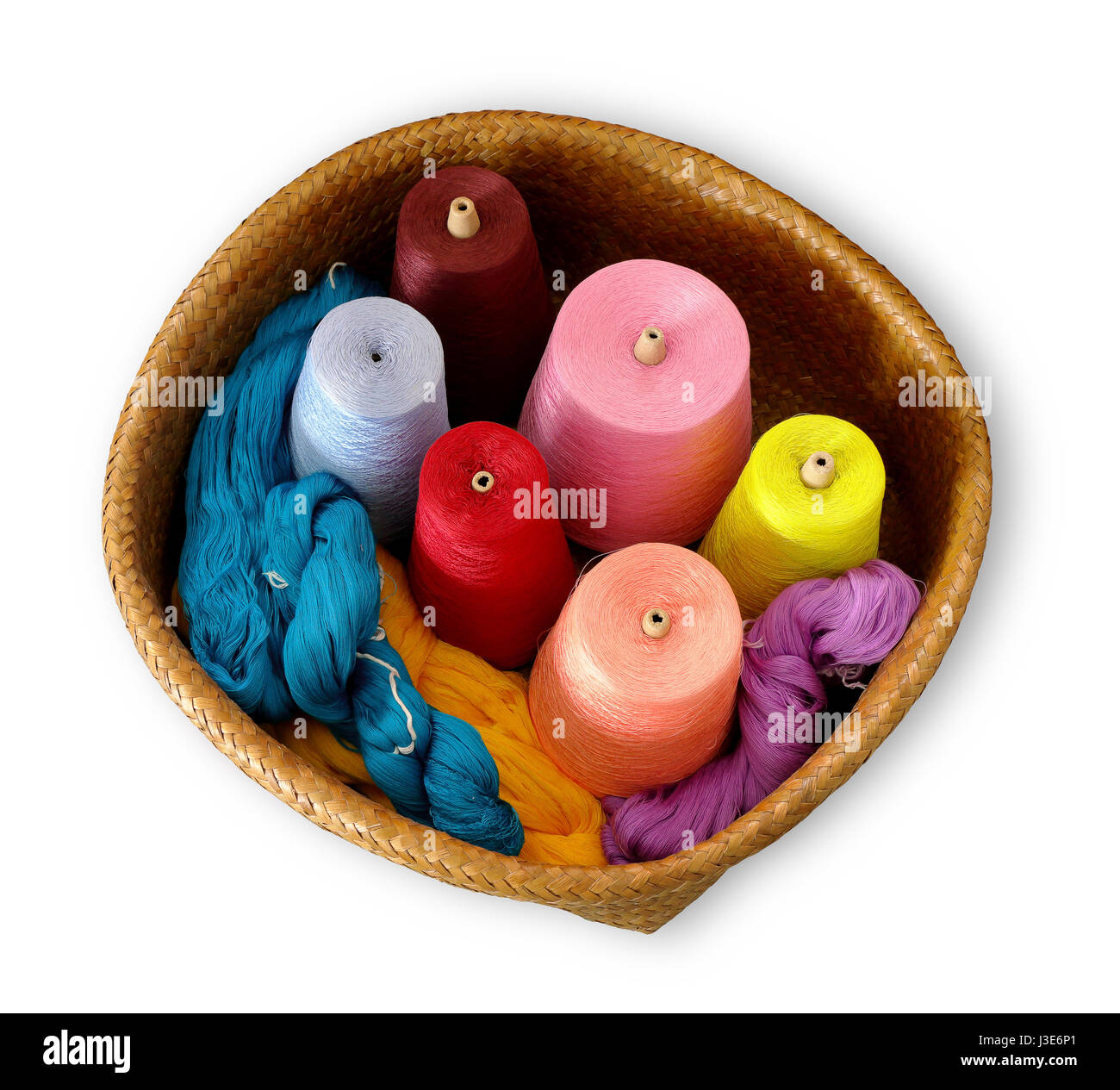 Spools of thread in a wicker basket in white background with top view ...