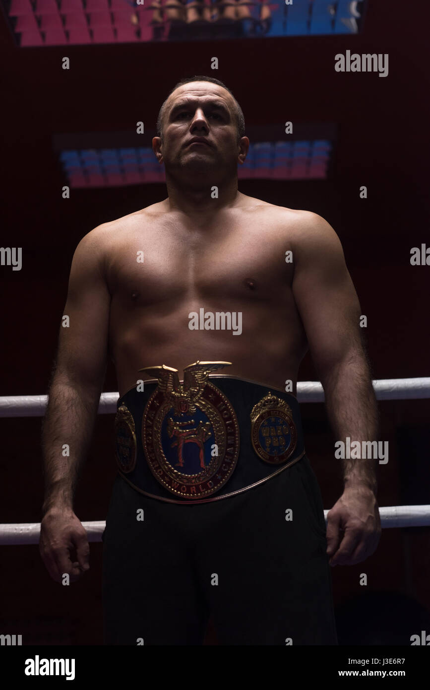 portrait of muscular professional kick boxer with his championship belt ...