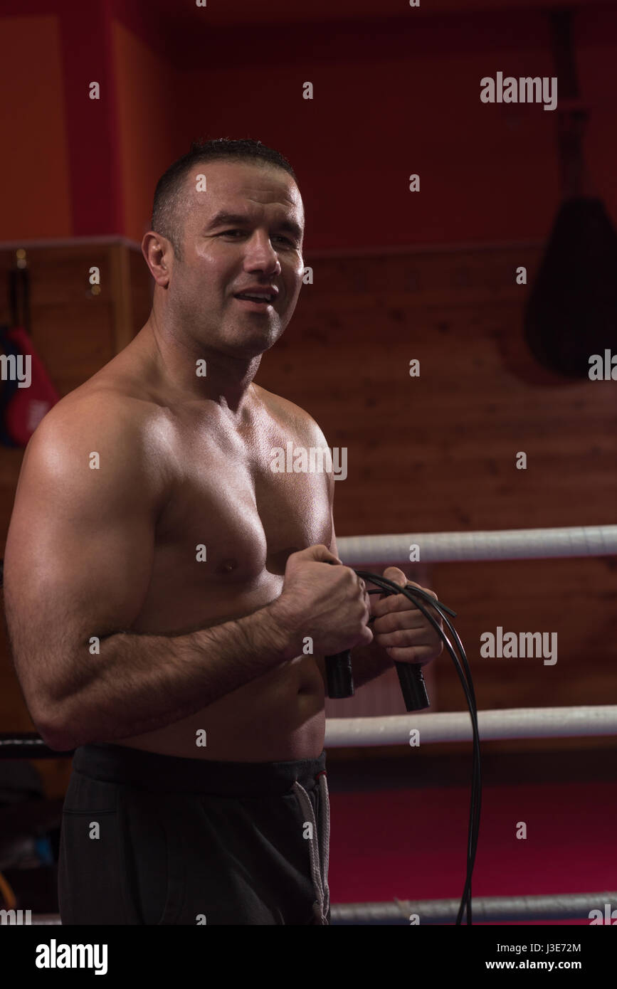 portrait of muscular professional kickboxer who standing in the ring ...