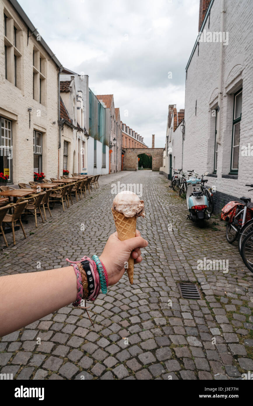 Woman holding an ice cream against medieval cityscape in Bruges ...