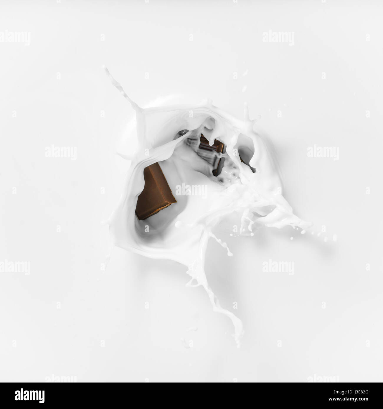 Chocolate falling in milk splashing hi-res stock photography and images ...