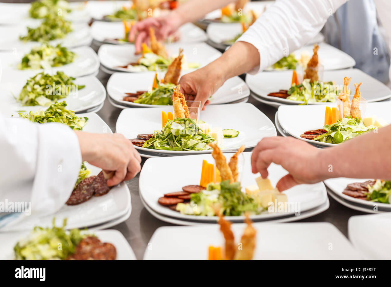 Cooks are preparing delicious appetizer dishes on restaurant kitchen ...