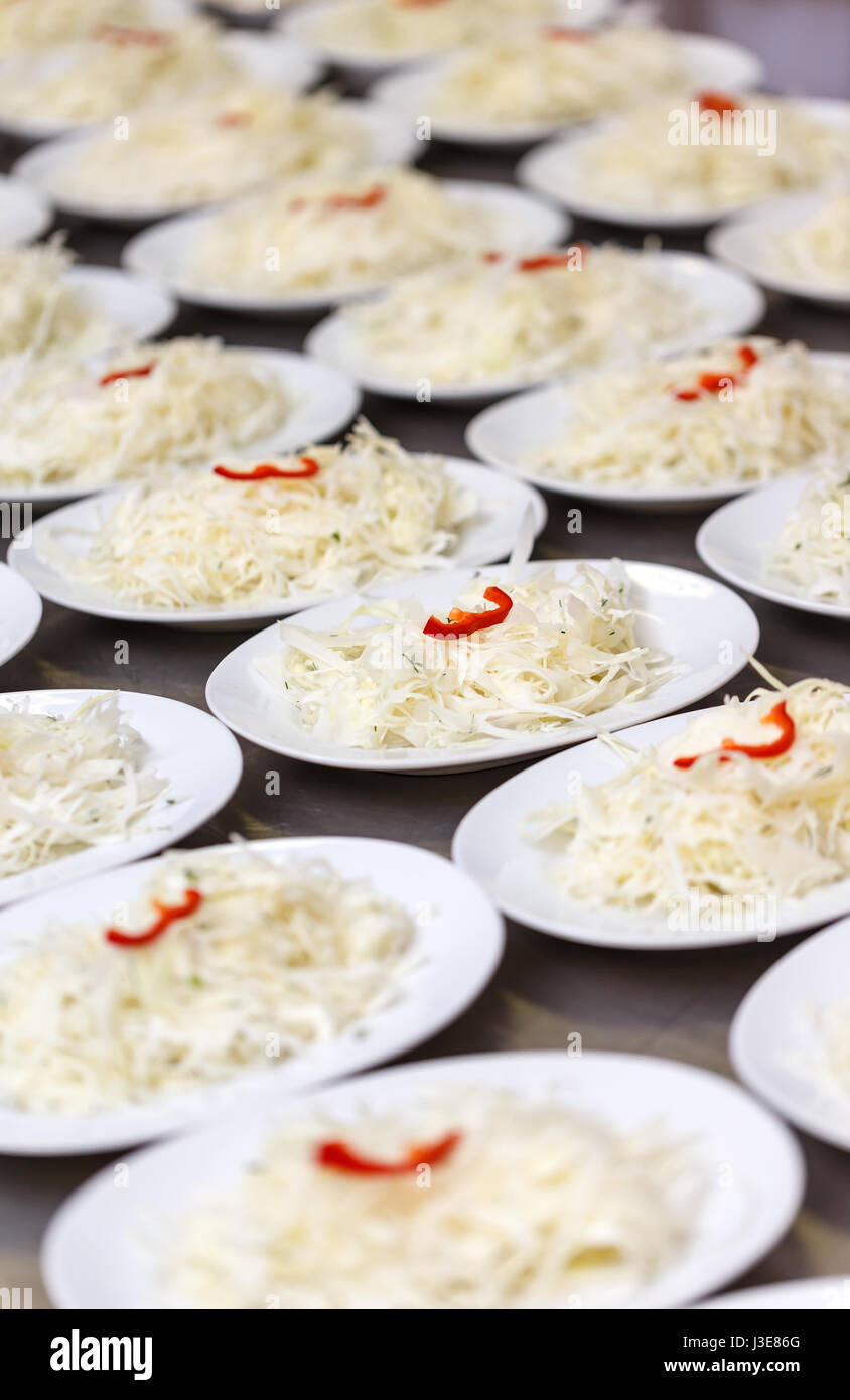 Lot of white plates with shredded cabbage Stock Photo - Alamy