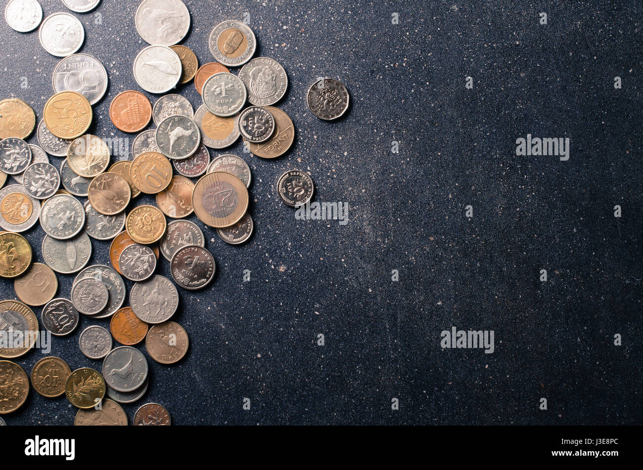 Different coins on dark background Stock Photo - Alamy