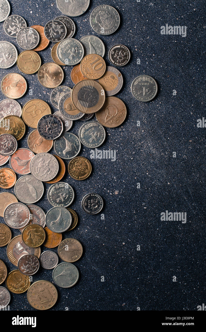 Different coins on dark background Stock Photo - Alamy