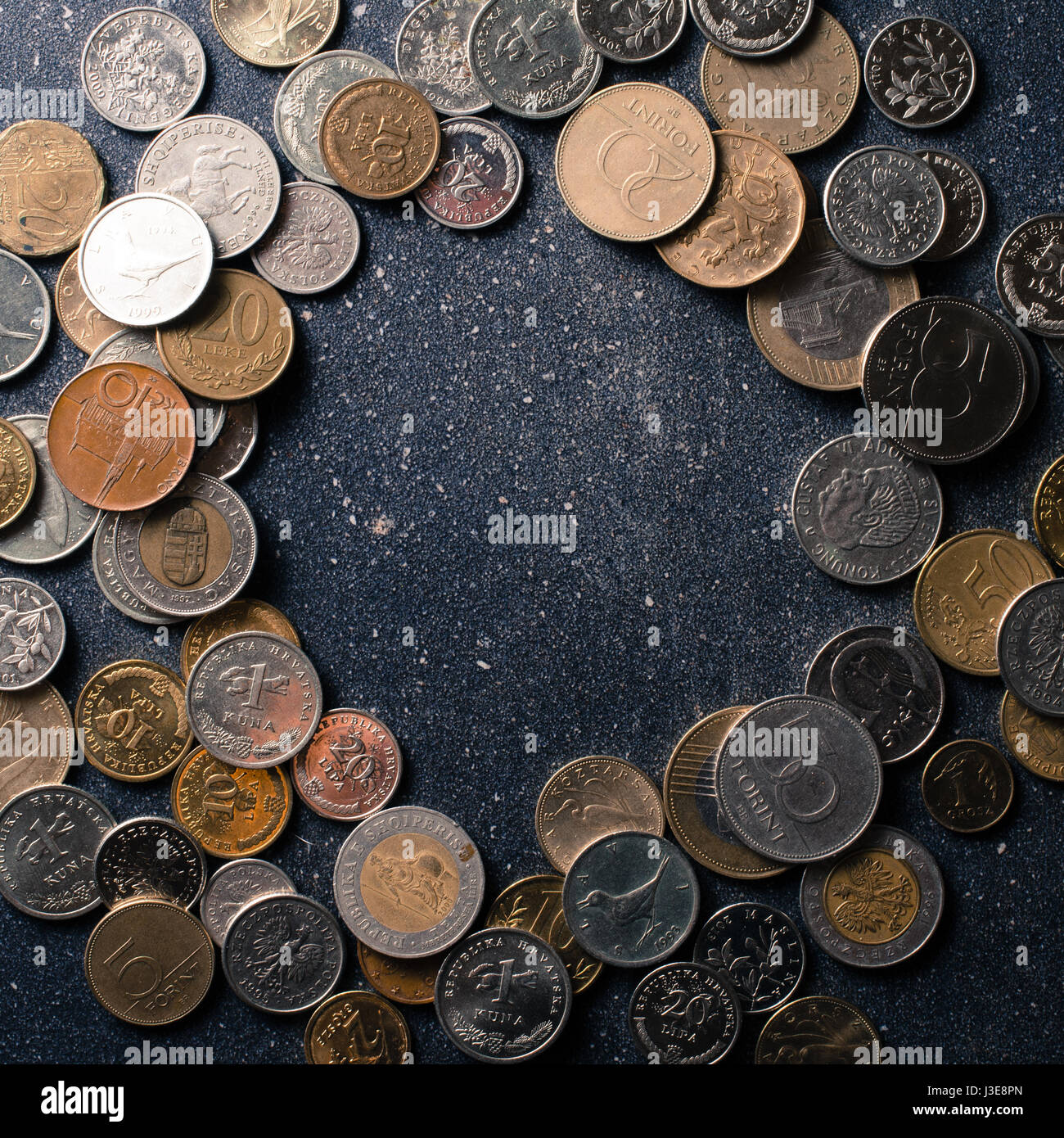 Different coins on dark background Stock Photo - Alamy