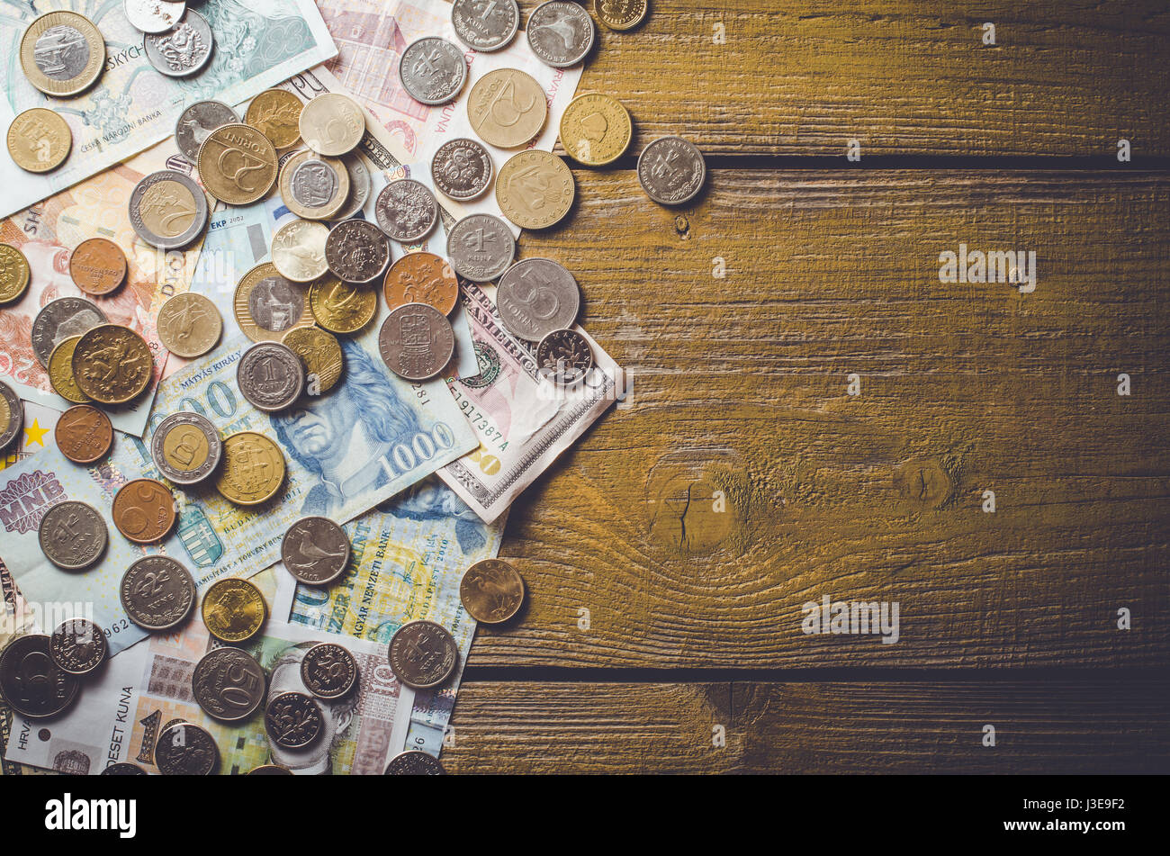 Different banknotes and coins on wooden table Stock Photo - Alamy