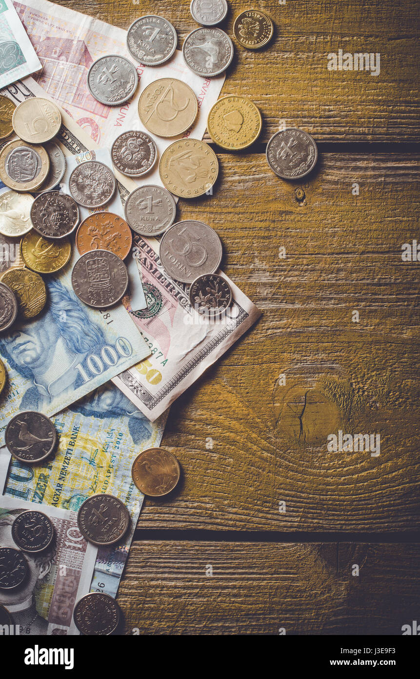 Different banknotes and coins on wooden table Stock Photo - Alamy