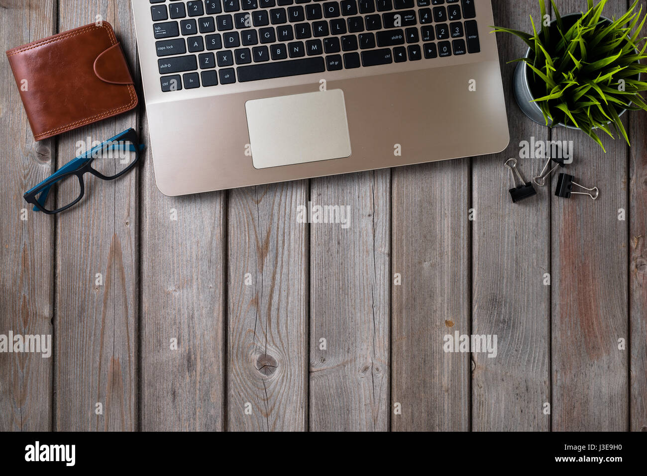 Overhead shot of office table with computer, plant and business ...