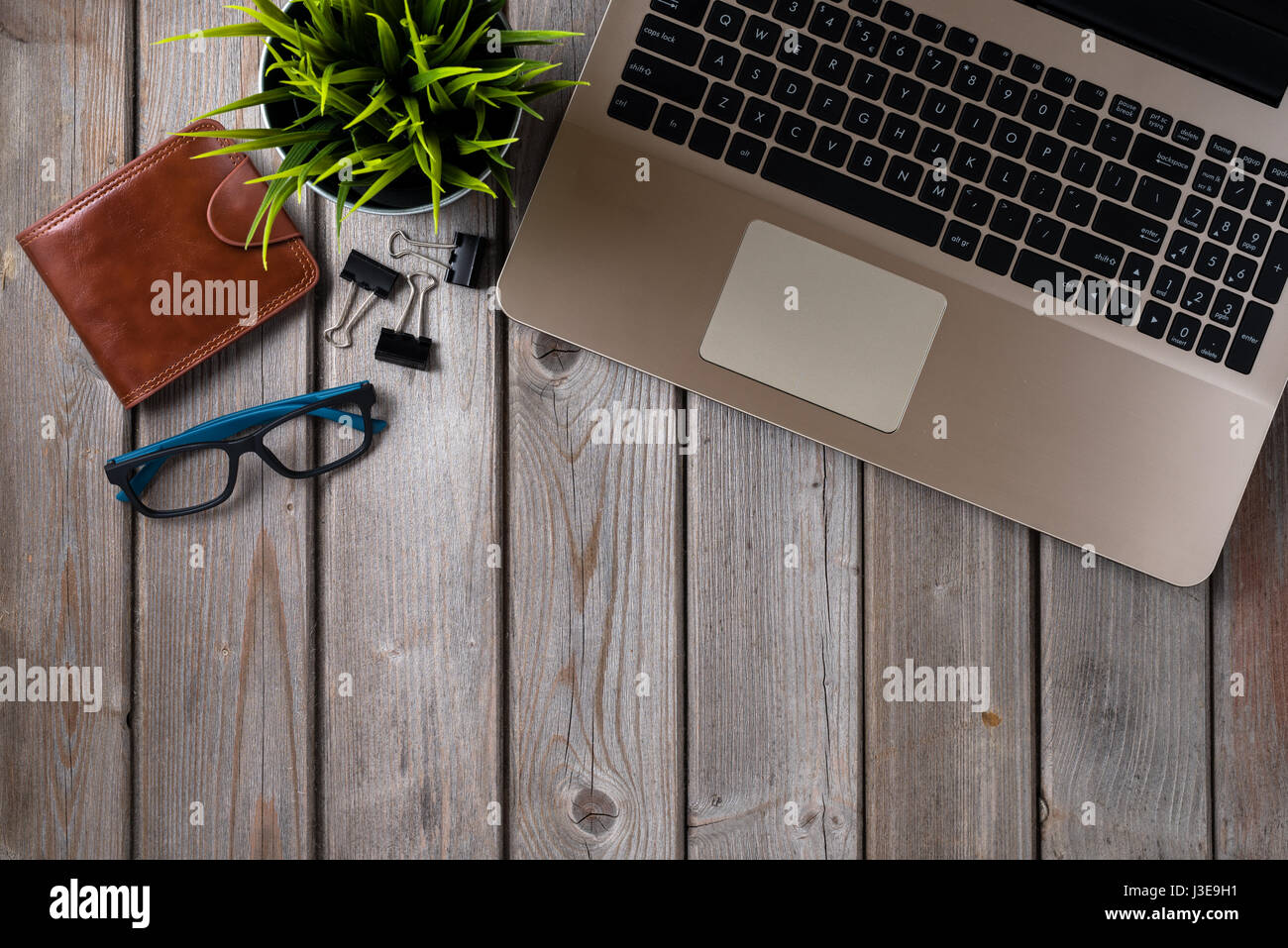 Overhead shot of office table with computer, plant and business ...