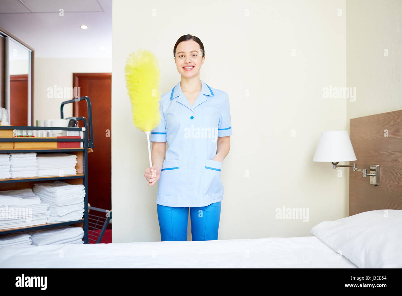 Maid with duster Stock Photo - Alamy