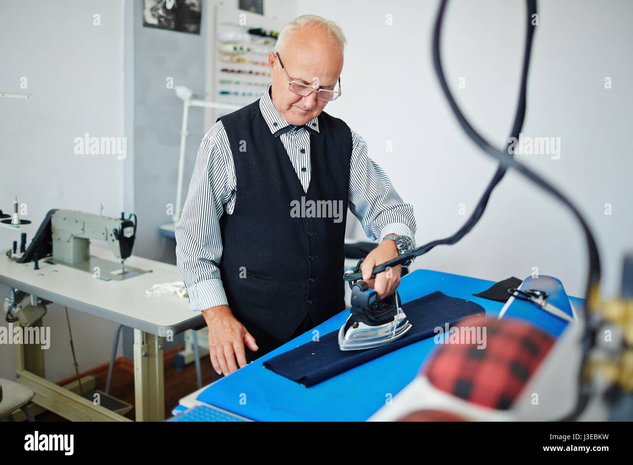 Old Tailor Working in Small Atelier Studio Stock Photo - Alamy