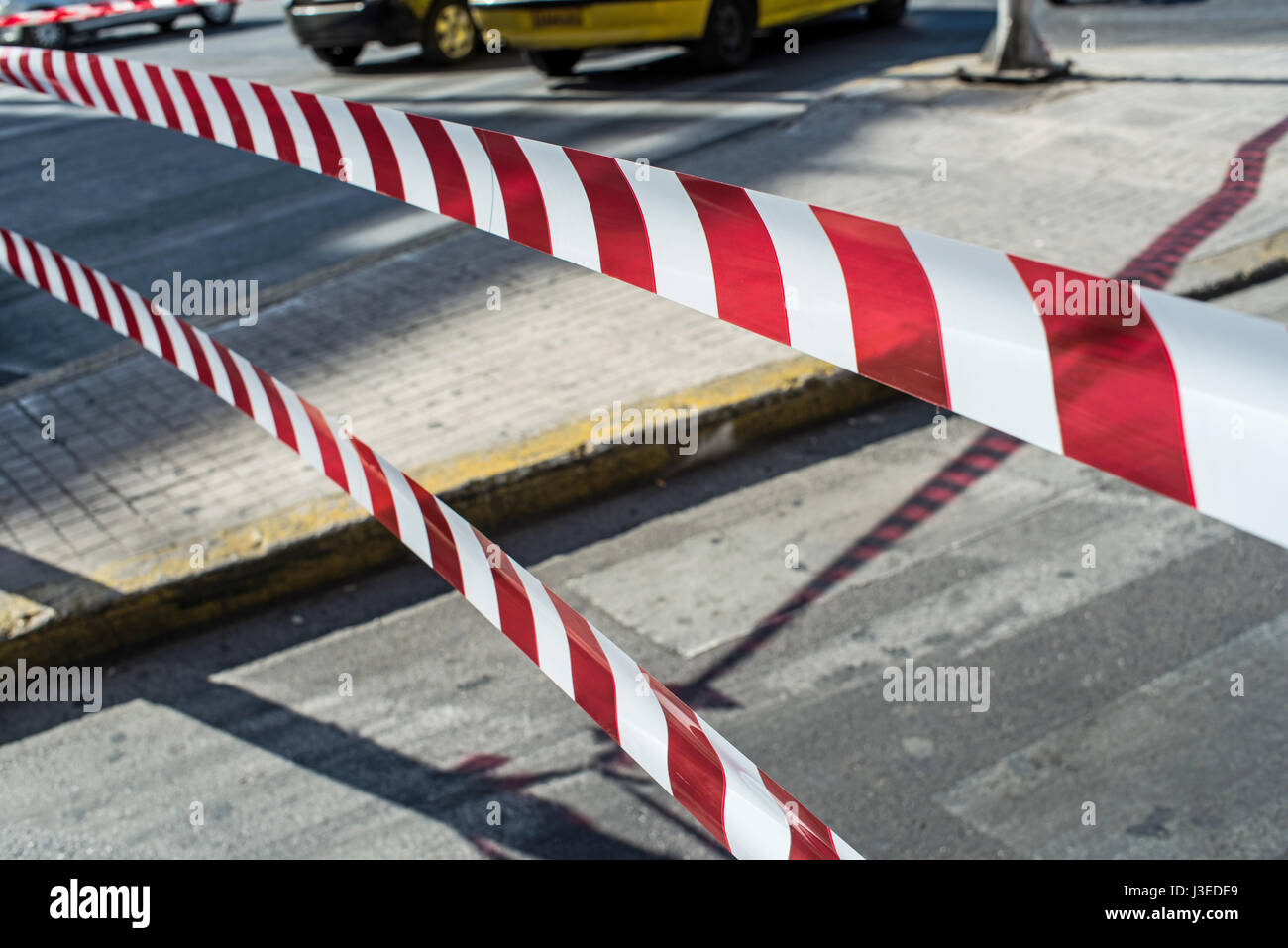 Red and white striped security tape. police closing the traffic of the ...