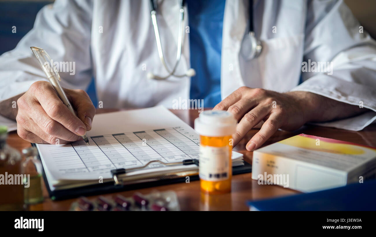 Doctor writing patient notes on a medical examination or prescription ...