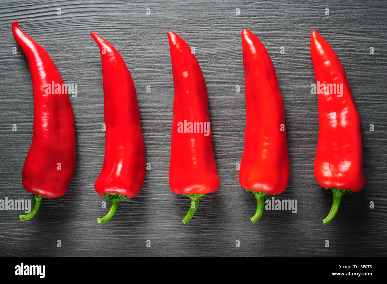 Five ripe sweet red Kapia peppers on dark shale stone background Stock ...